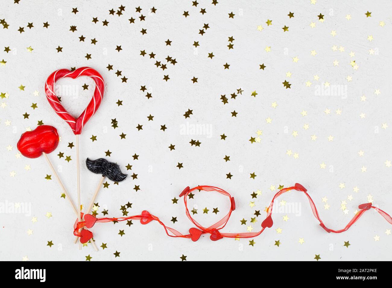 red and black lollipop in shape of heart, lip and mustache on white ...