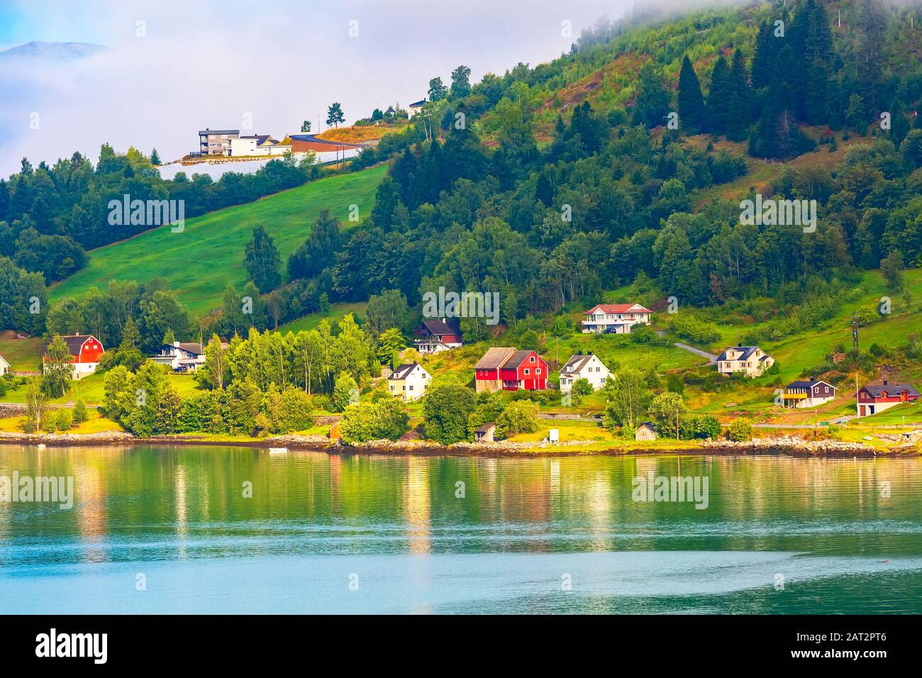 Norwegian village landscape with fjord, mountains with clouds and ...