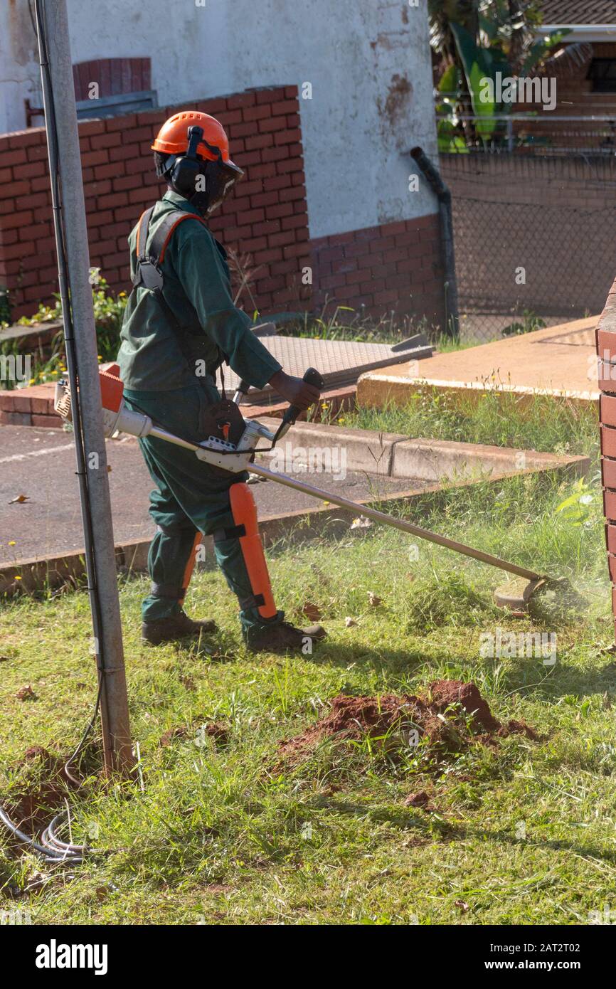 A close up view of a municipal worker cutting the grass on the edge of ...