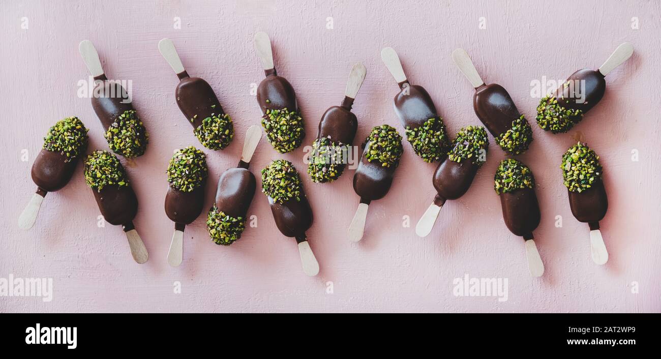 Flat-lay of chocolate glazed ice cream pops with pistachio icing Stock ...