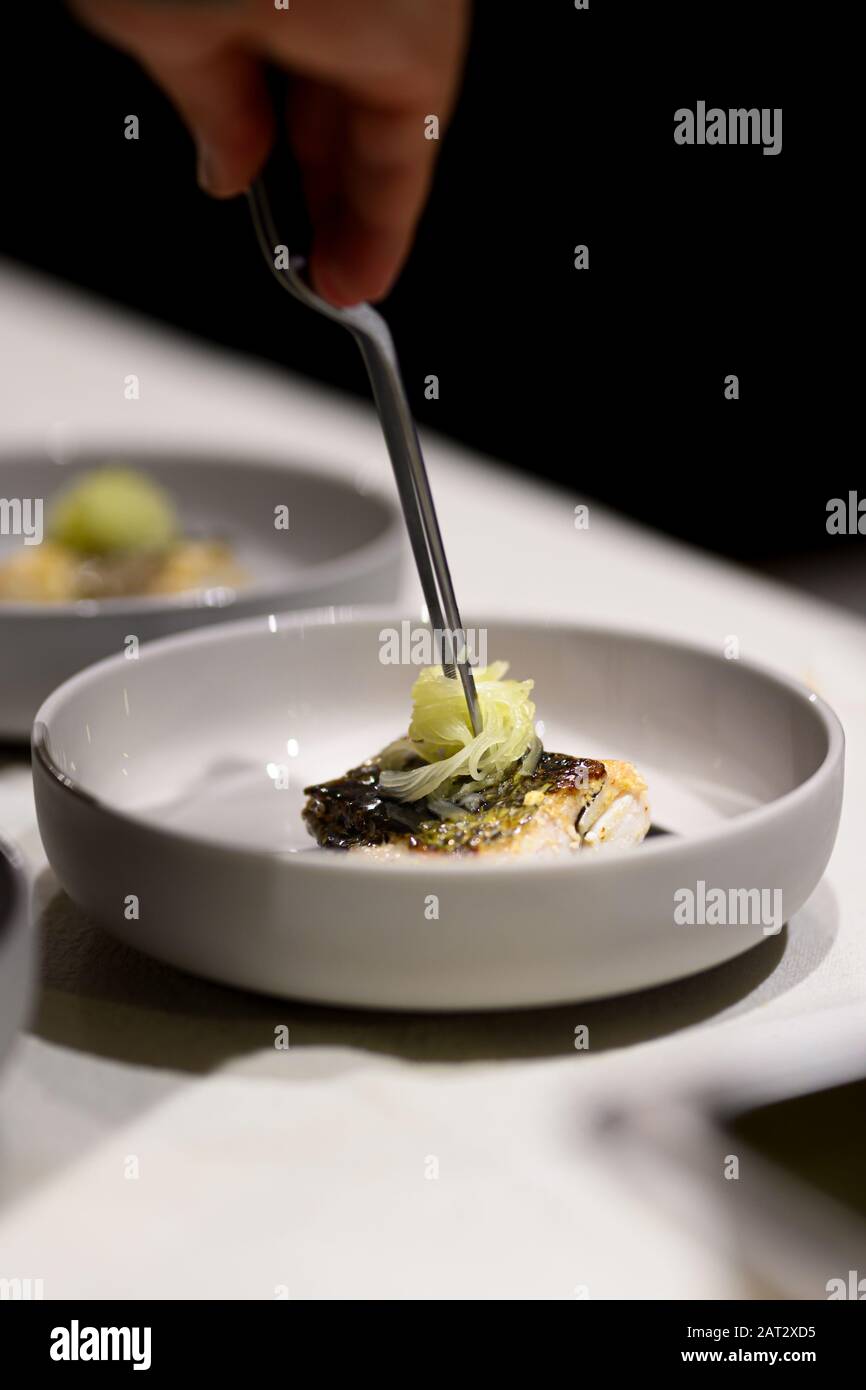 Grilled fish being plated Stock Photo - Alamy