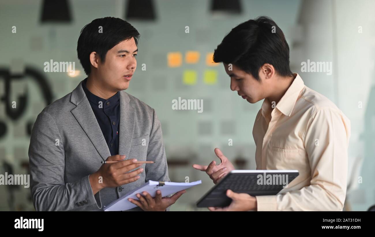 Photo of young business consulting man while talking/giving an advice ...