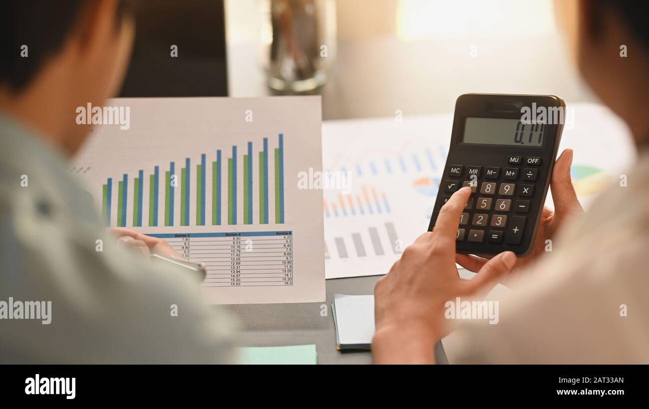 Behind shot of young business development team are calculating ...