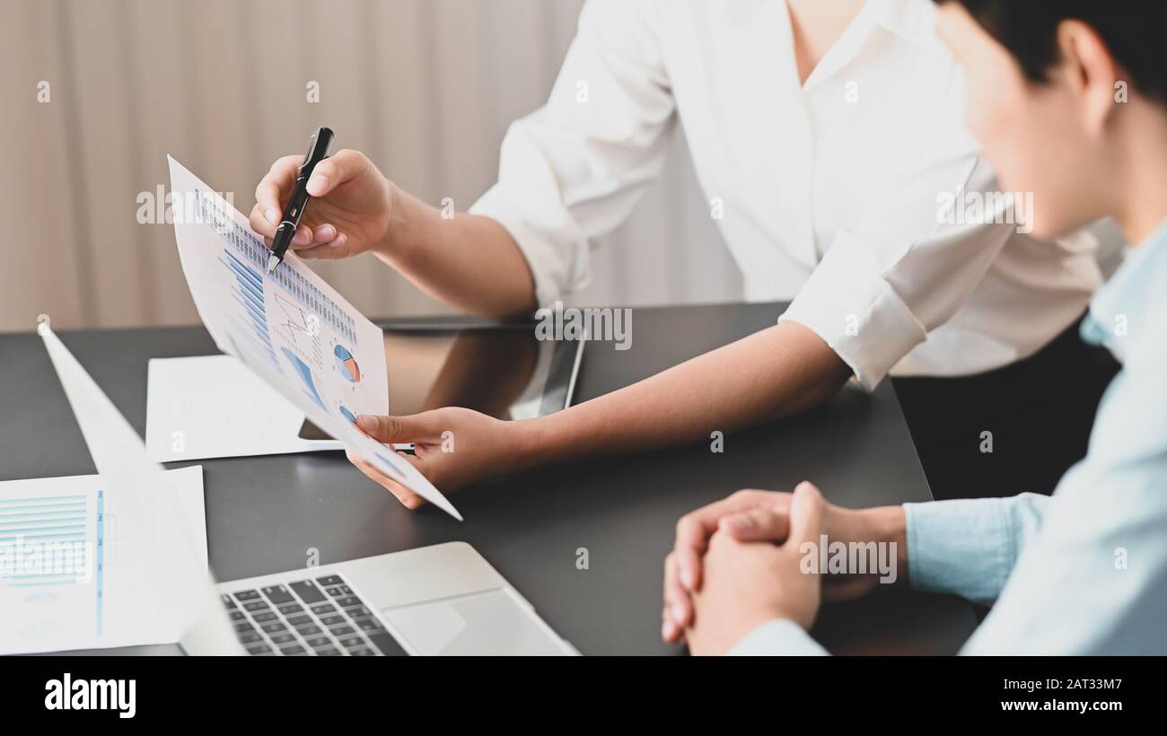 Business consultant showing a business graphic chart report to her ...
