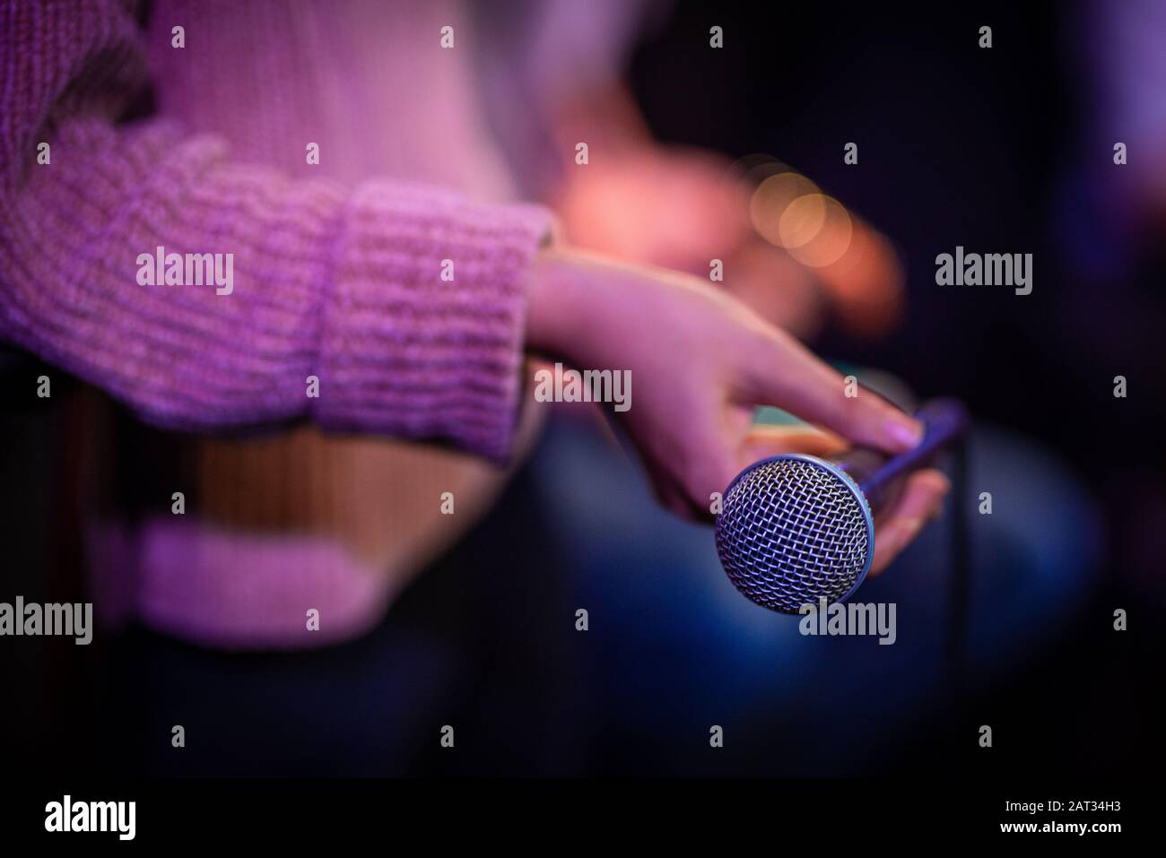 Woman's hand holding microphone Stock Photo - Alamy