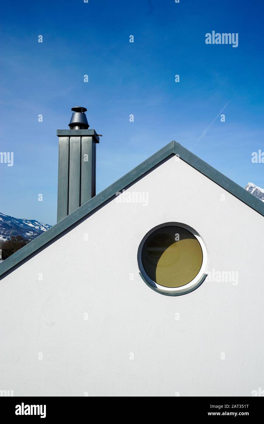 A close up view of a white house front with a gable roof and window and ...