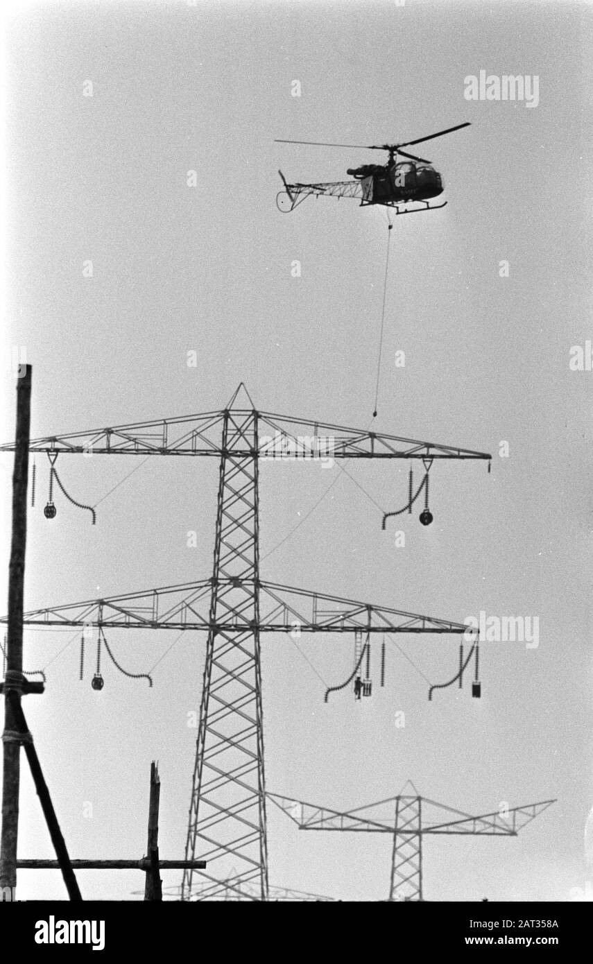 A helicopter helps with the construction of power lines between the ...