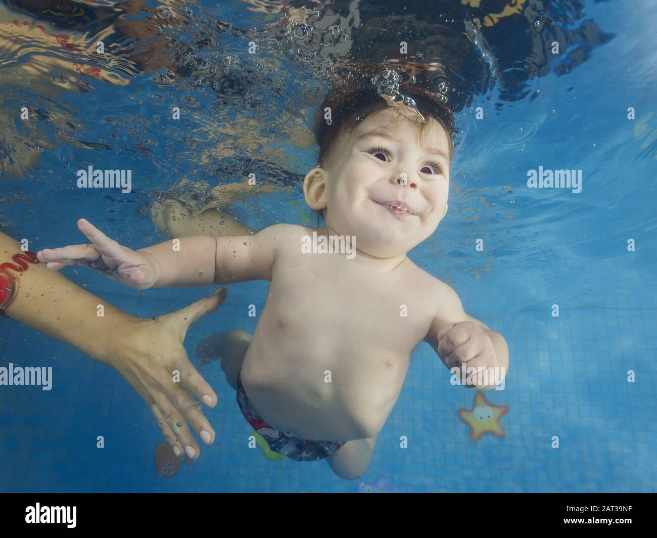 Little baby learning to swim underwater in a swimming pool hi-res stock ...