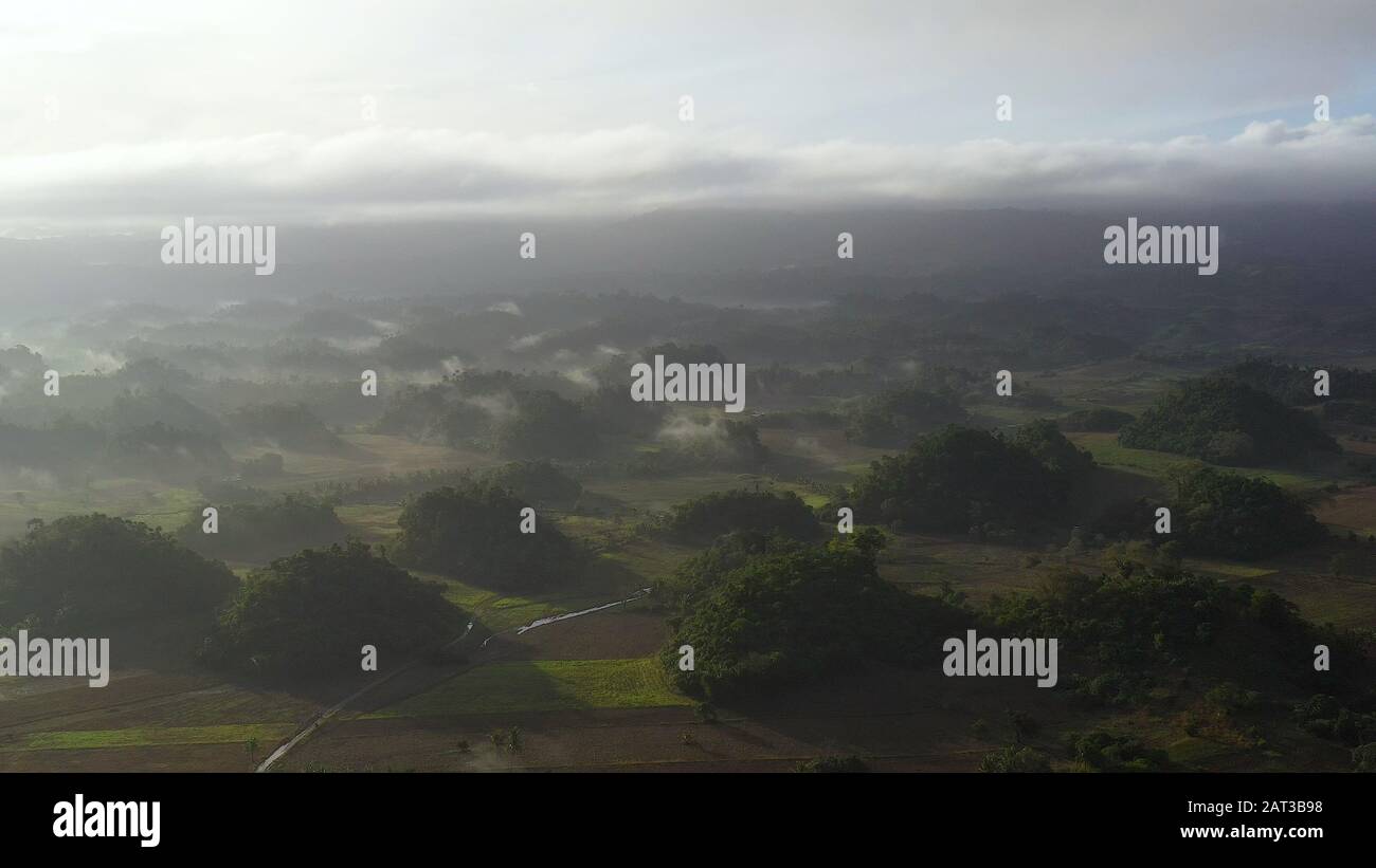 Tropical landscape with farmland and green hills, aerial view. The ...