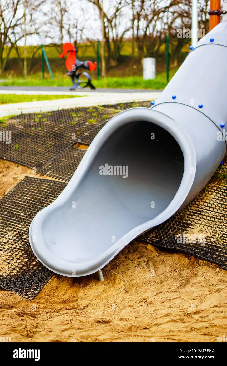 Side view shot of the base of a tube slide in a children's playground ...