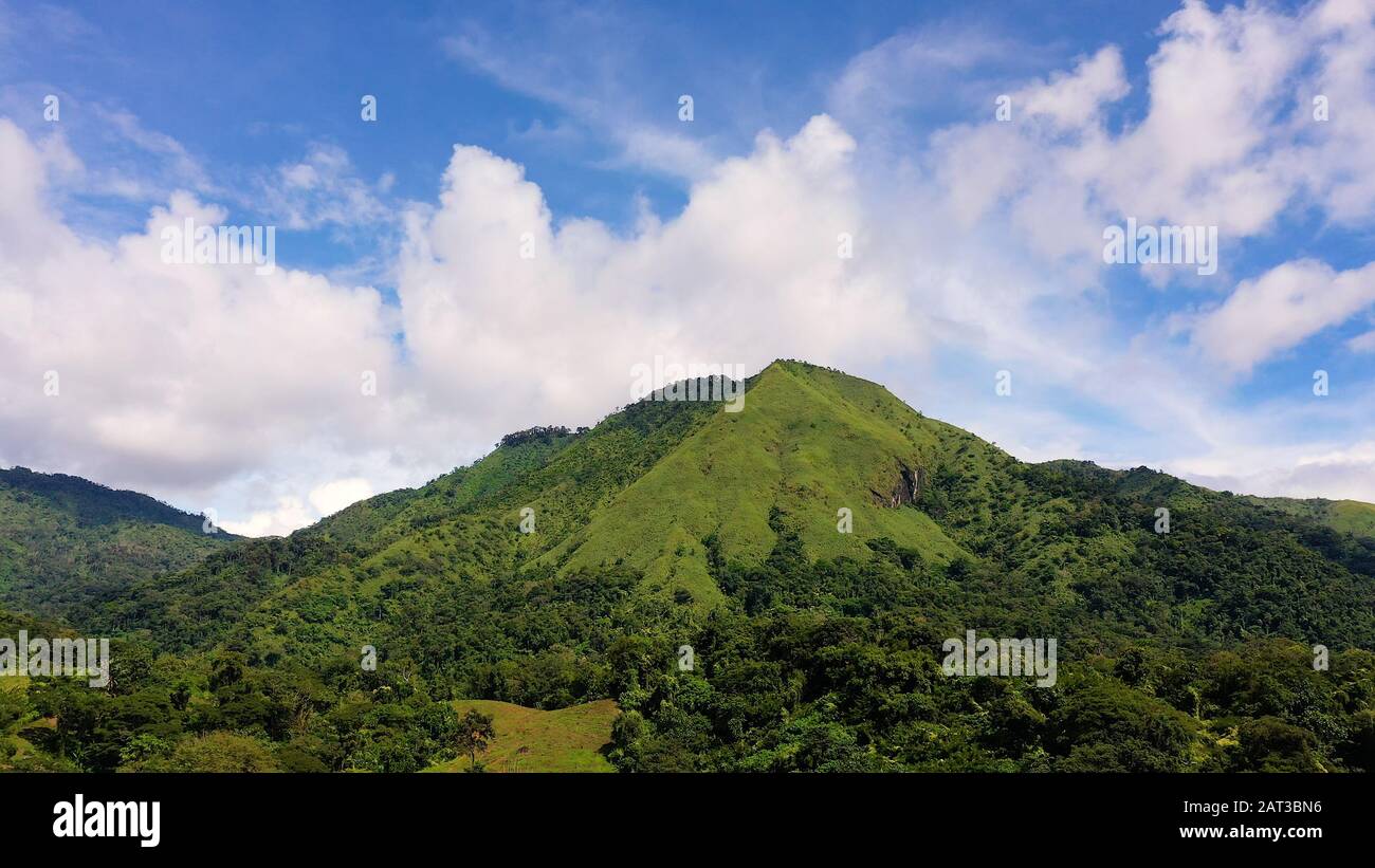 Hills with green grass and blue sky with white puffy clouds. Beautiful ...
