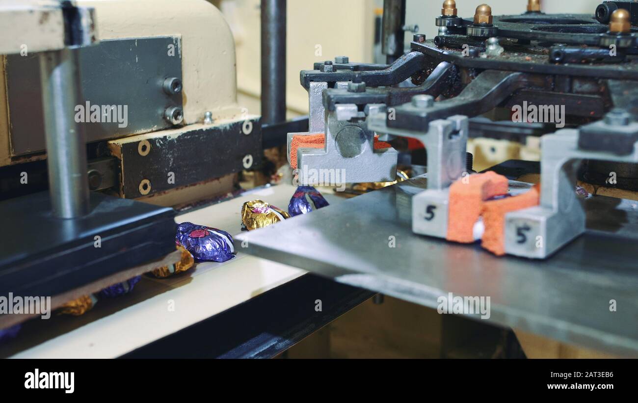 Candy factory. Industrial machine wrapping candies. Modern industrial ...
