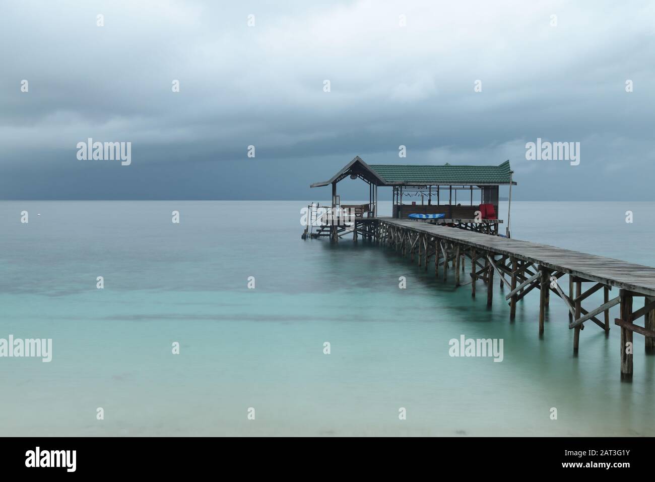 Wooden jetty on a tropical island with cloudy sky.Raja Ampat, West ...