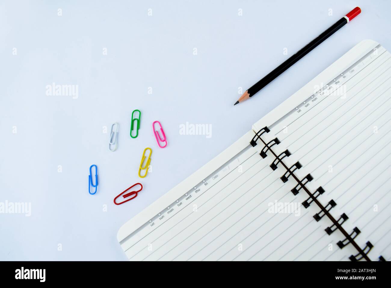 Study materials which contains a dark black pencil,a white notebook and ...