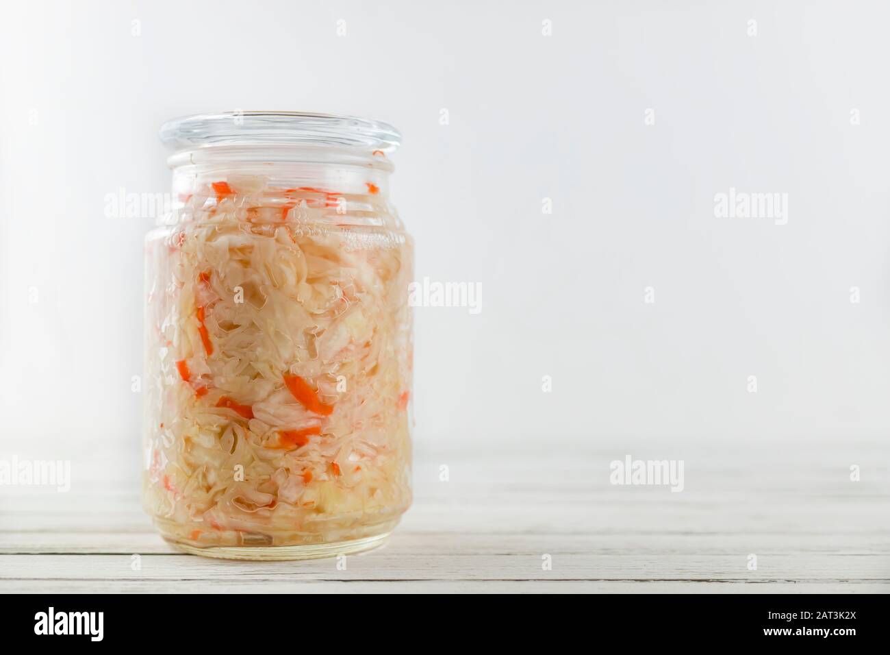 glass jar of fermented white cabbage. vegetables on a light background ...