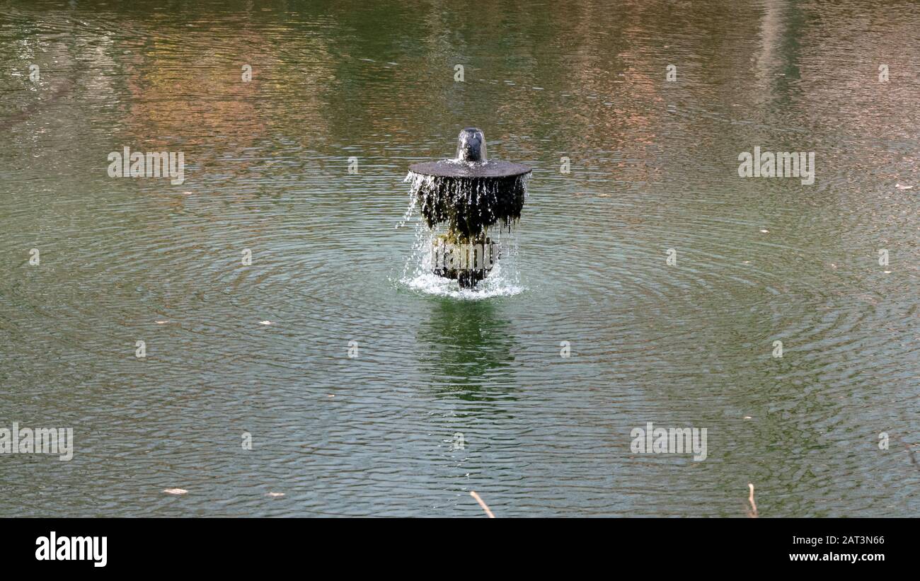 Fountain in the middle of the pond Stock Photo - Alamy
