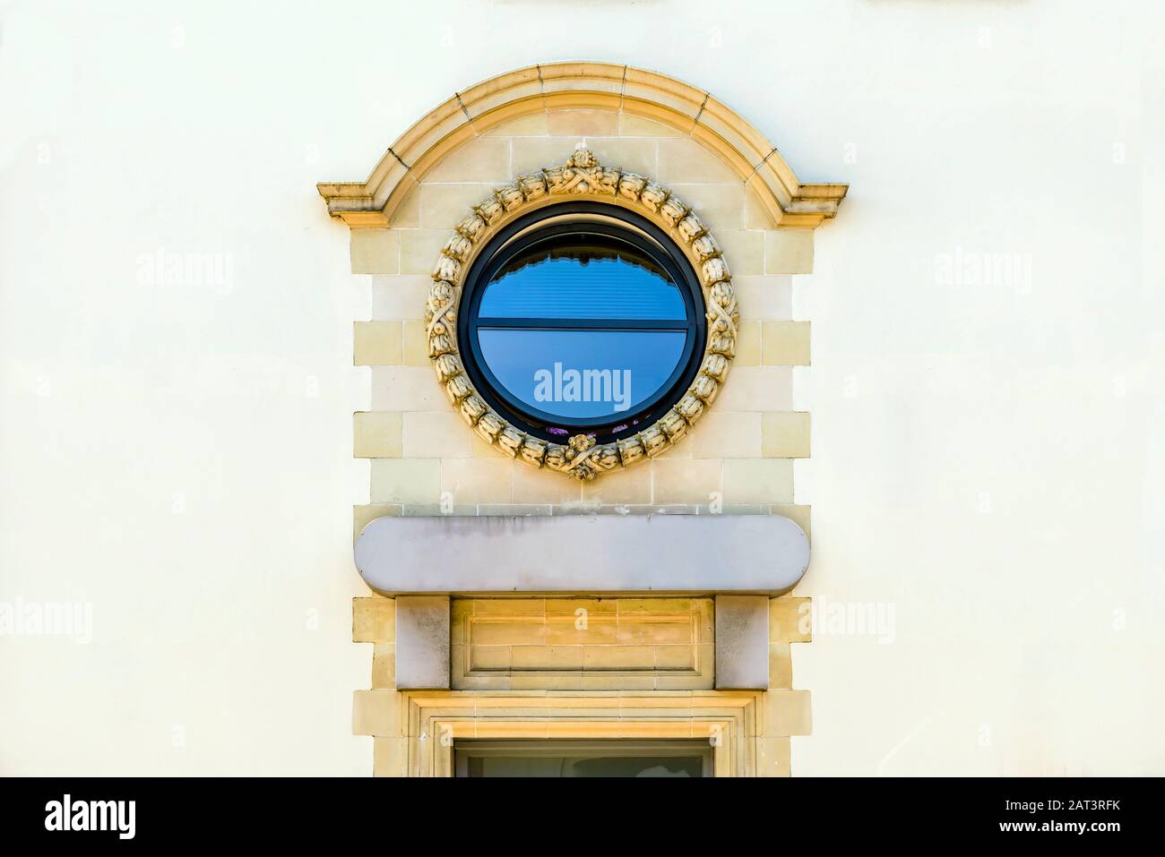 round window over entrance door on bright building wall in england uk ...