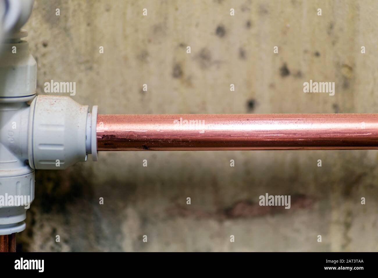 new copper pipe over mouldy concrete wall in england uk Stock Photo - Alamy