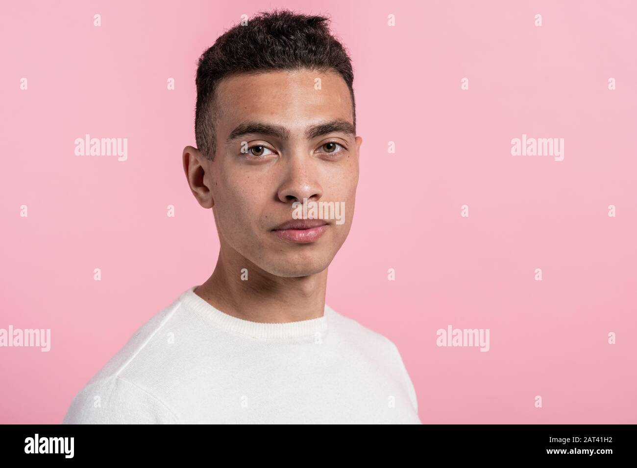 Closeup half-turn face portrait of mulatto man posing in the studio ...