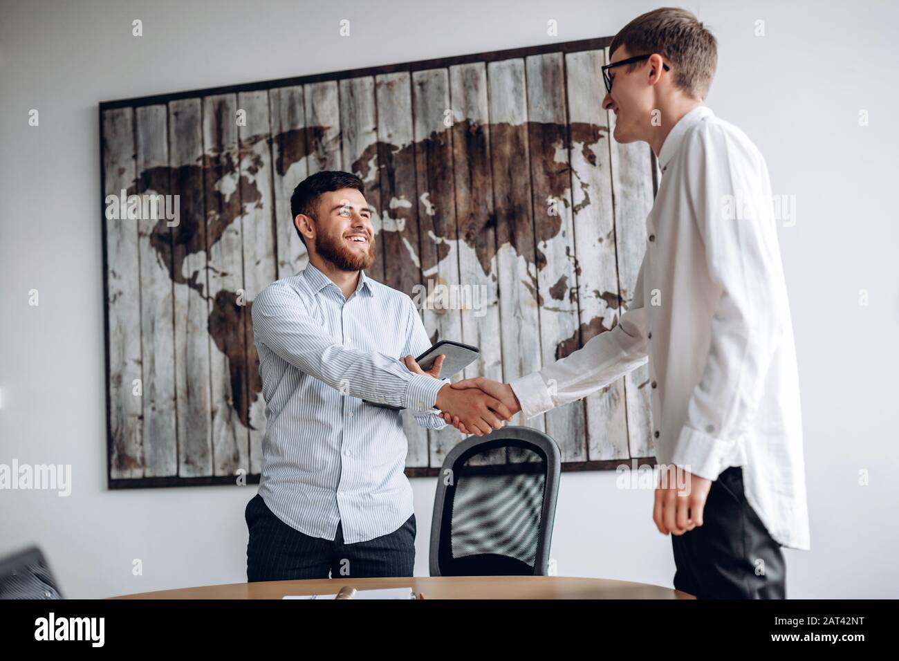 Young smiling guy shaking hands with his business partner Stock Photo ...
