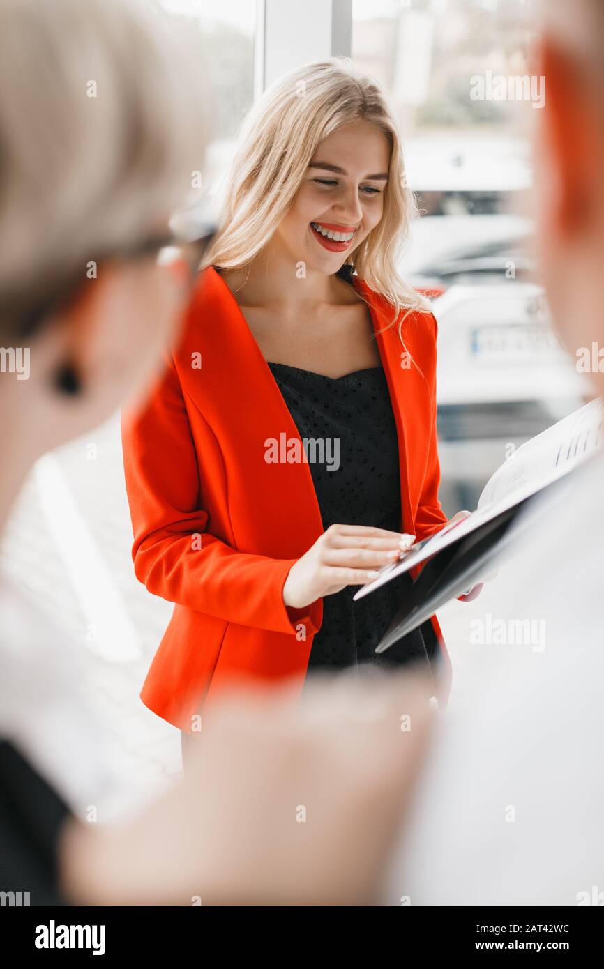 Car dealer smiling and standing next a client. Woman portrait . - Image ...