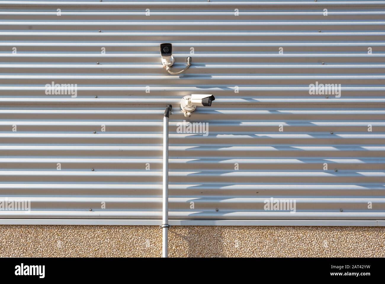 dual cctv cameras on wall shadows sunny day summer public spy watching ...