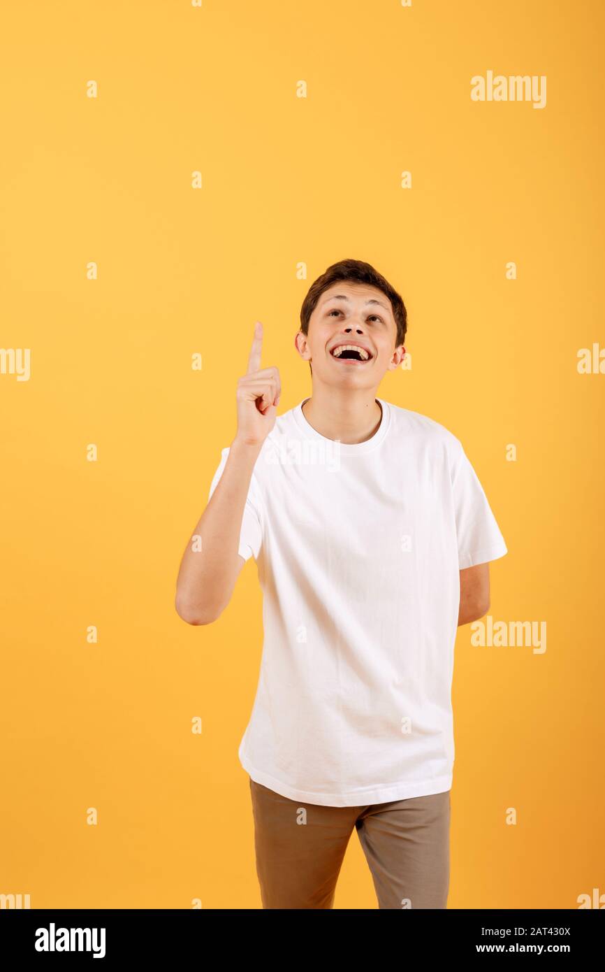 Handsome guy looking up and pointing his finger Stock Photo - Alamy