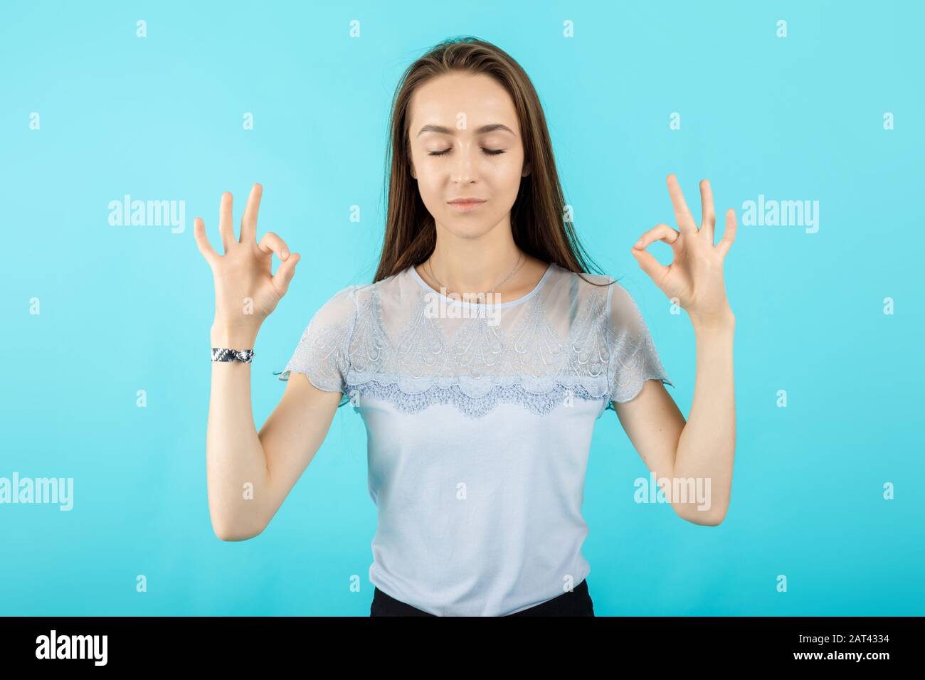Peaceful young beautiful girl practices breathing yoga exercises ...