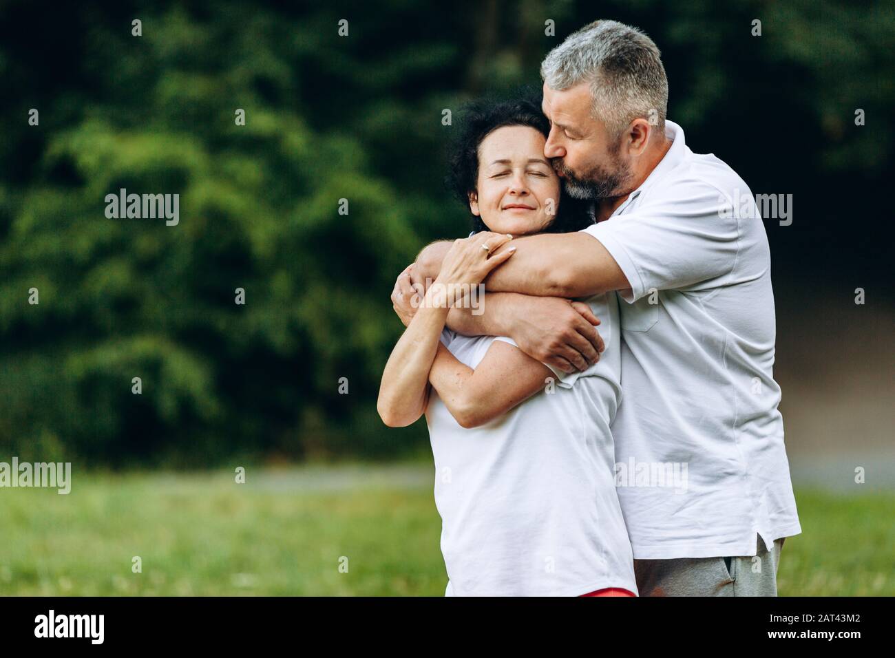 Senior woman and man standing and hugging outdoor,man kissing woman ...