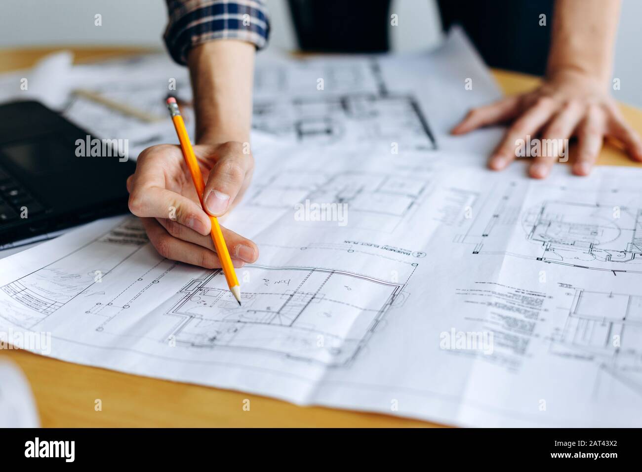 Engineer or architect holding pen with drawings in construction on ...