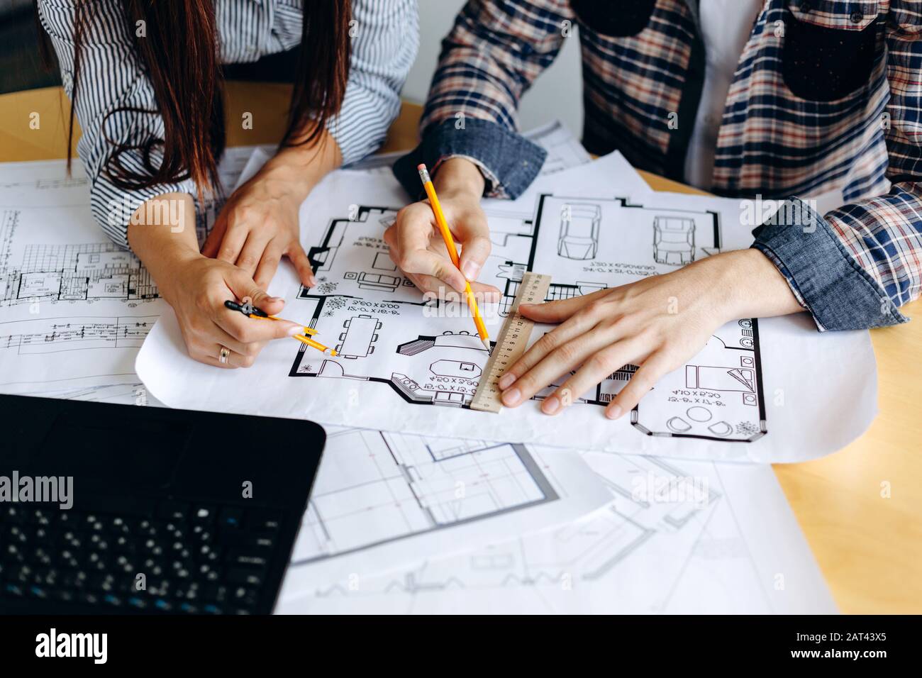 Two serious architects looking at blueprints on a table in the office ...