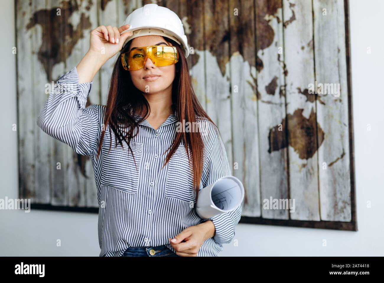 Attractive woman in helmet and blueprints working in office Stock Photo ...