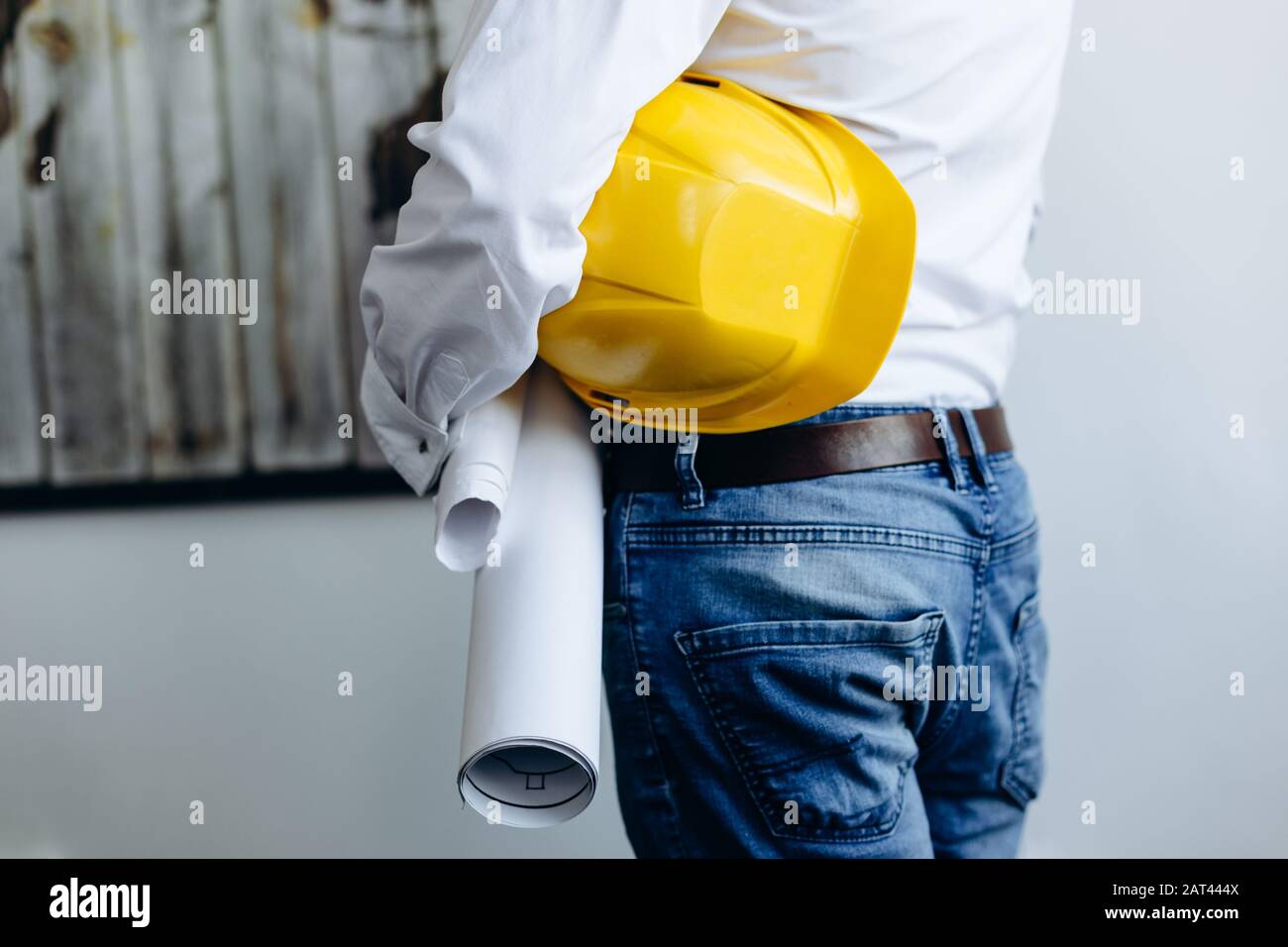 Architect with yellow helmet and blueprints plans work Stock Photo - Alamy