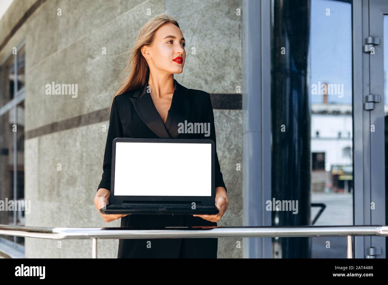 Woman holding a blank mockup white screen of laptop.- Horizontal image ...