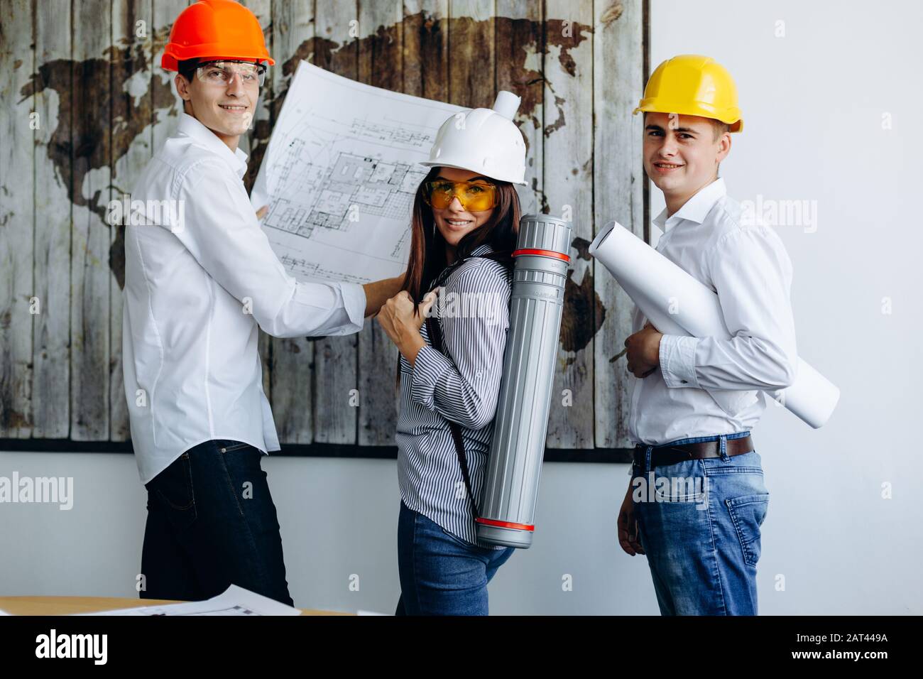 Smiling young engineers working on blueprints in the office Stock Photo ...