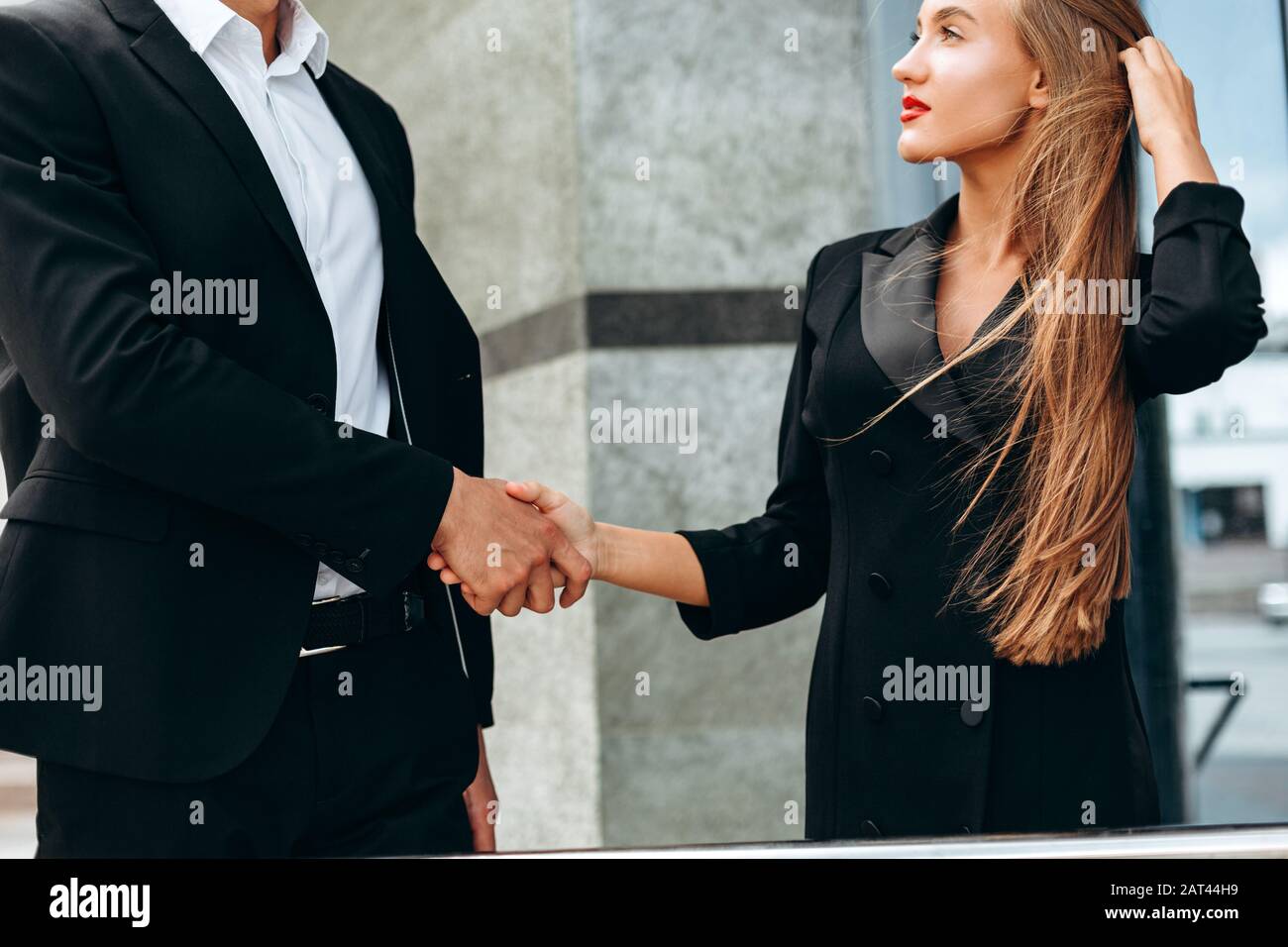 Man and woman shake hands. Woman looking at the man Stock Photo - Alamy