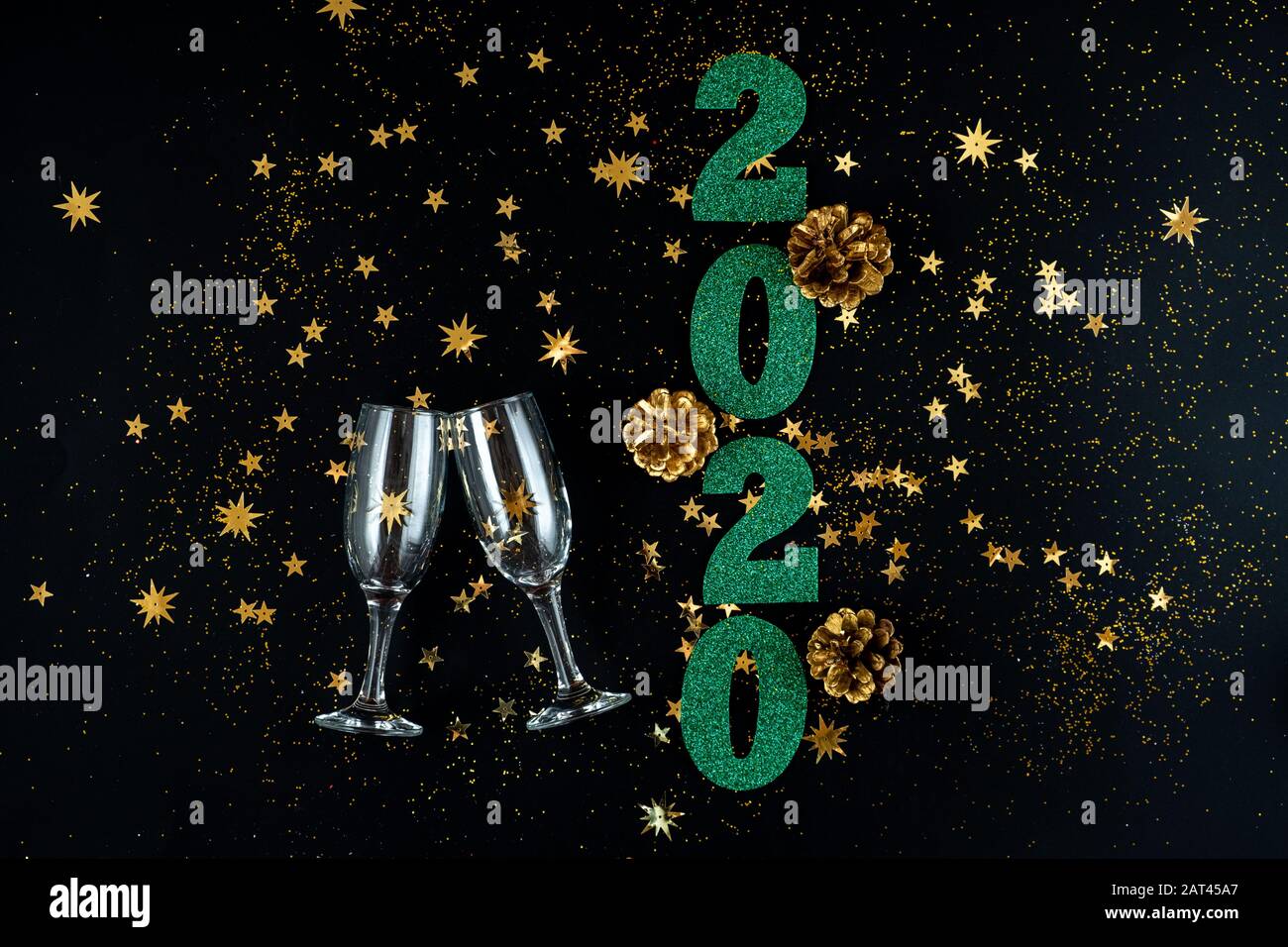 Green numbers 2020 New Year, cups, gold cones, and gold stars on a ...