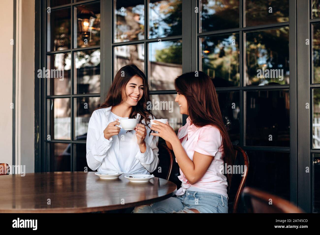 Beautiful girlfriends have fun in cafe Stock Photo - Alamy