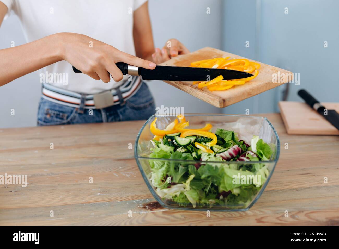 Woman working in the kitchen chopping up the vegetables. Female slicing ...