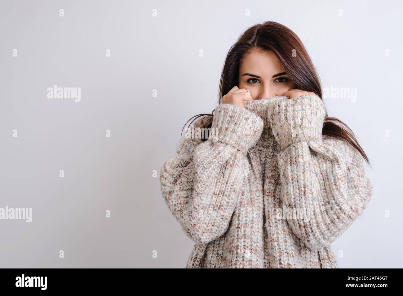 Beautiful girl covers her face with a sweater Stock Photo - Alamy