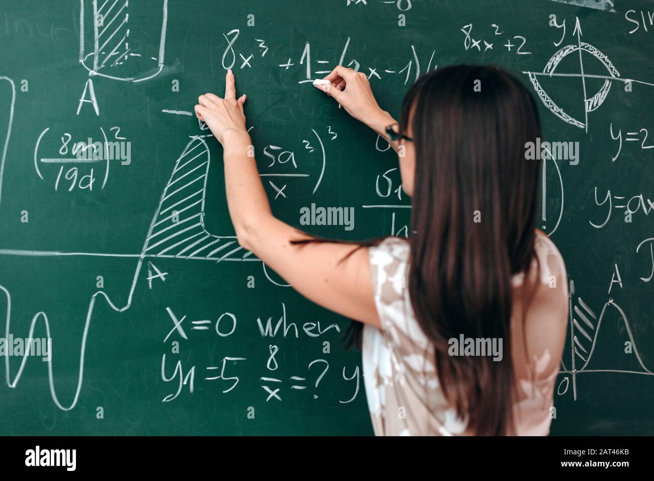 Closeup a chalkboard. Teacher pointing to the example and explain a ...