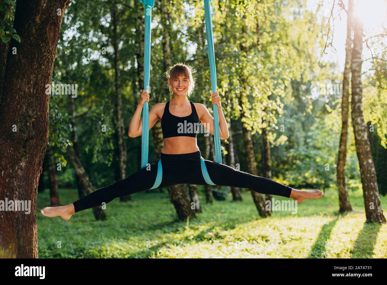 Happy Girl Doing Fly Yoga Outdoors Spreading His Legs Wide Apart