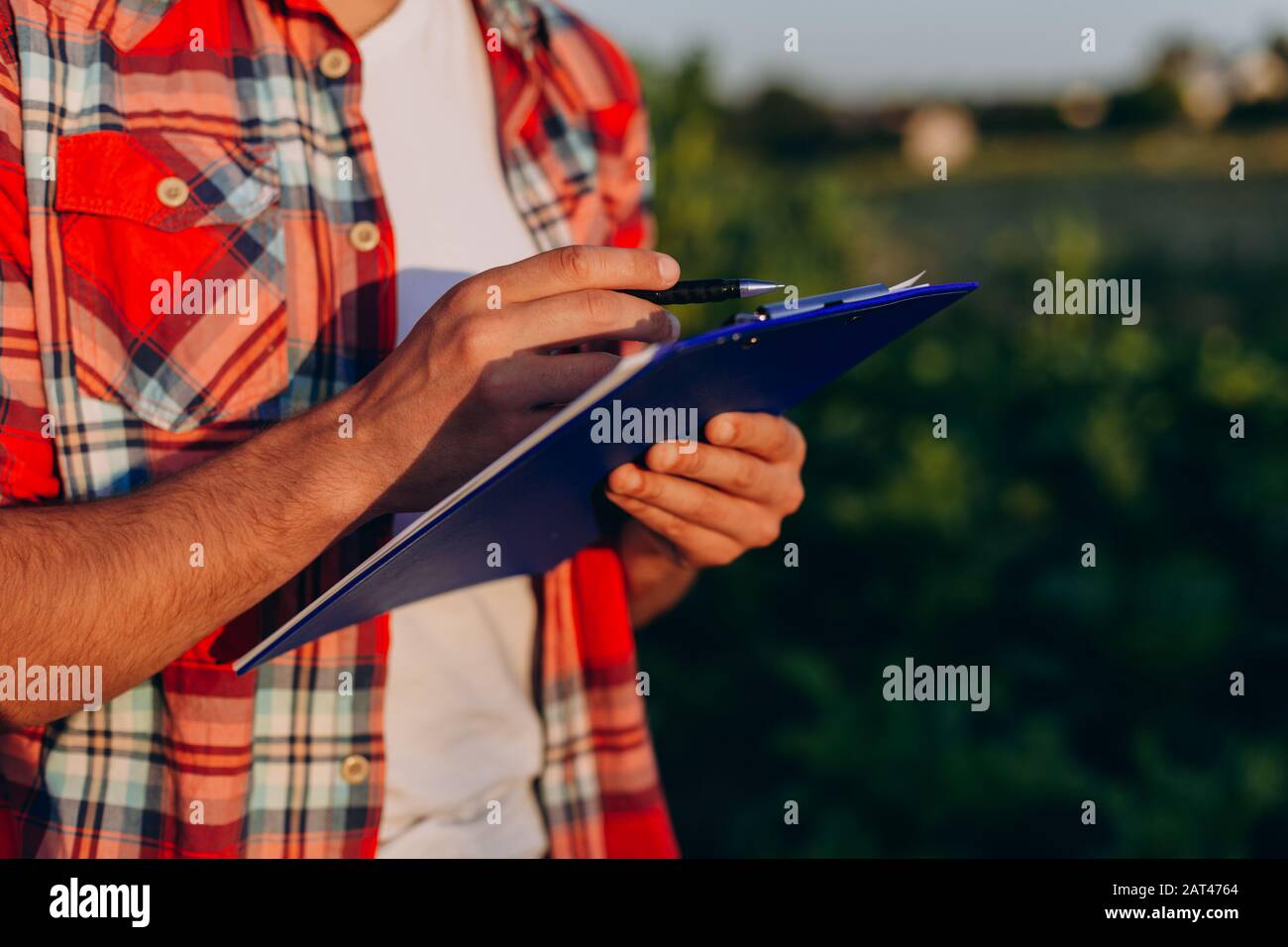Close Up male hands holding paper documents with pen and writing a ...