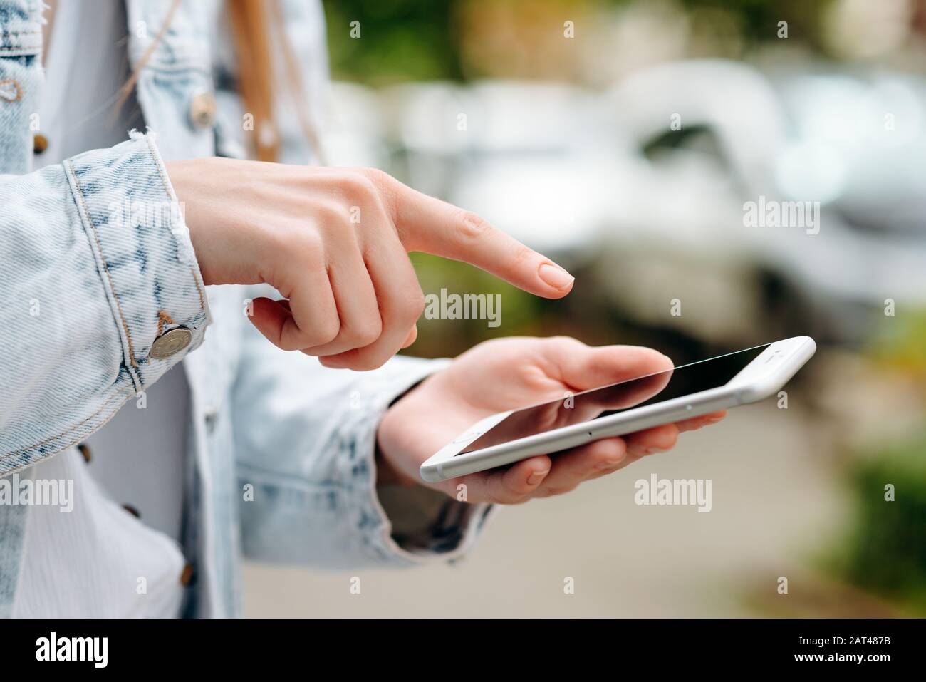Closeup female hand with a smartphone. Index finger pointing to screen ...