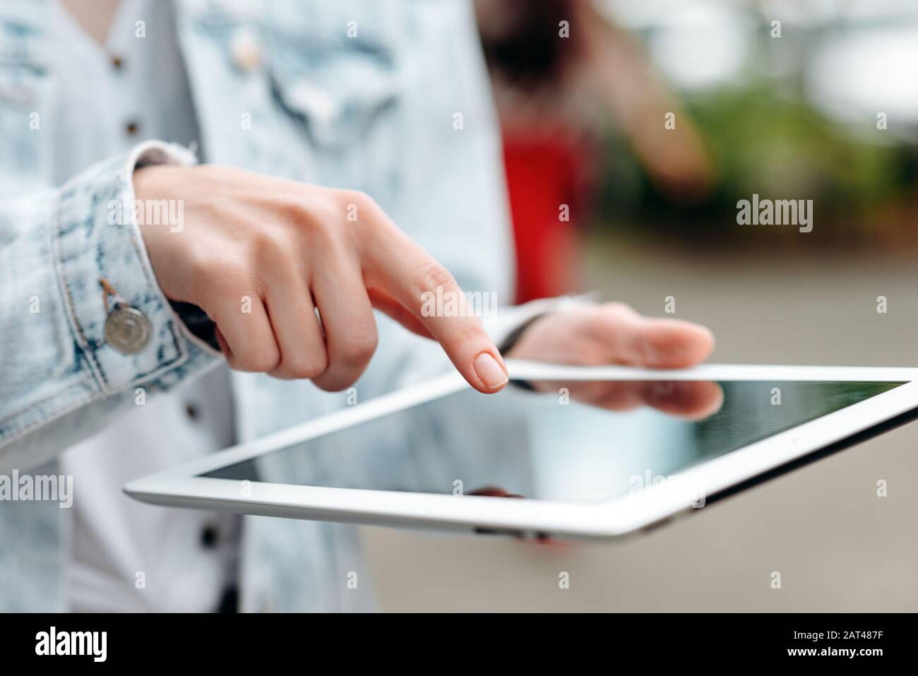 Closeup female hand with a ipad. Index finger pointing to screen ...