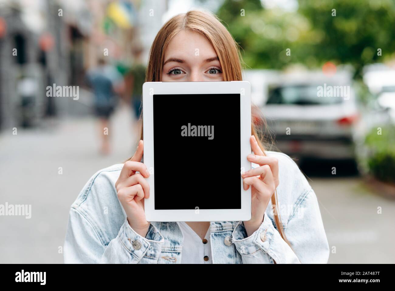 Empty black mockup ipad screen in female hands. Girl peeping from ...