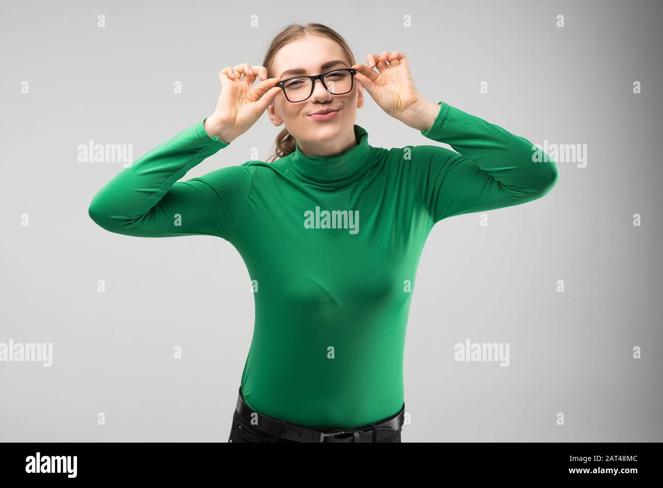 Girl teenager in glasses and in modest clothes have fun - play the ape ...