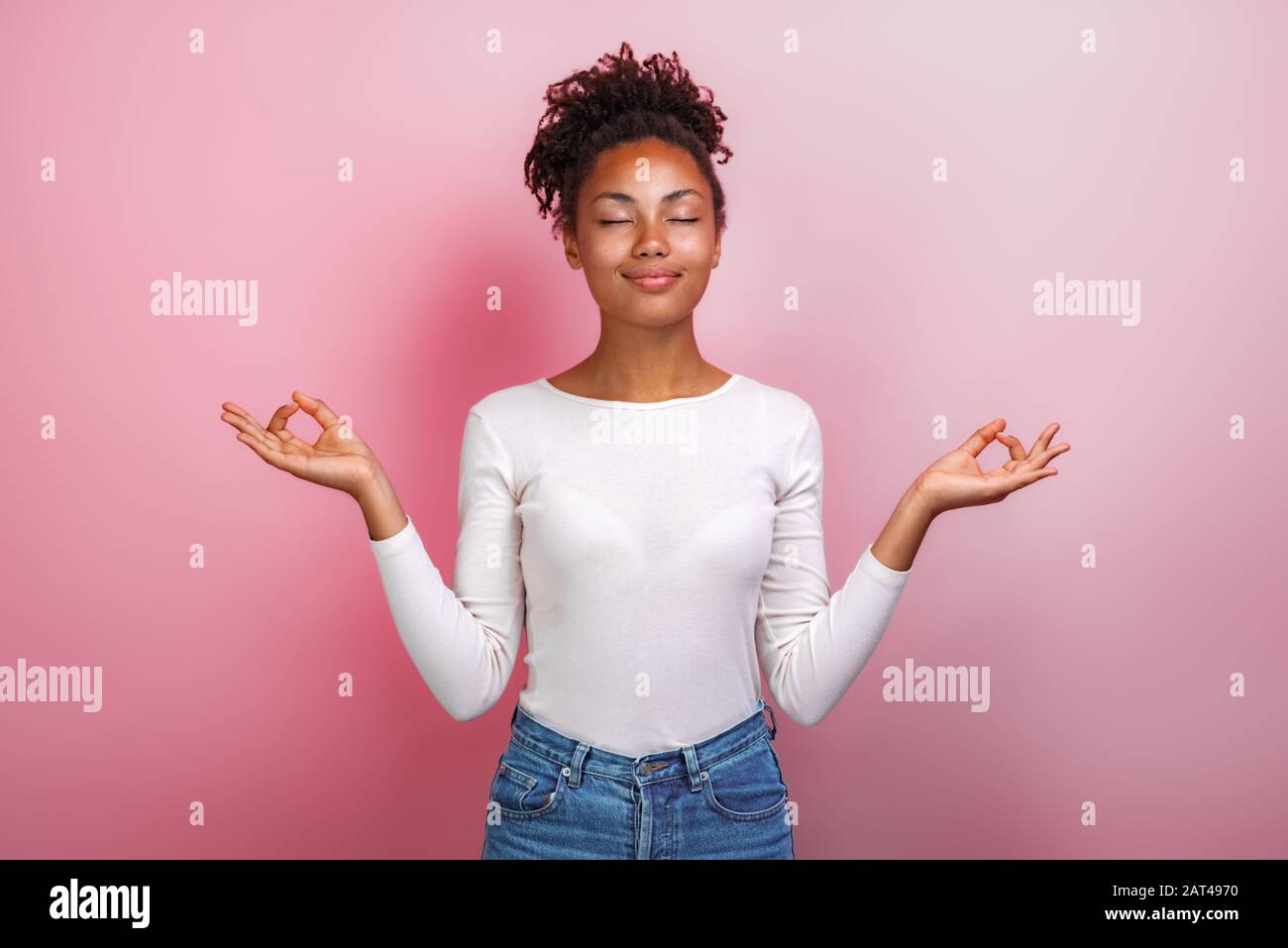 Pretty mulatto girl standing arms apart in the maditation gesture with ...