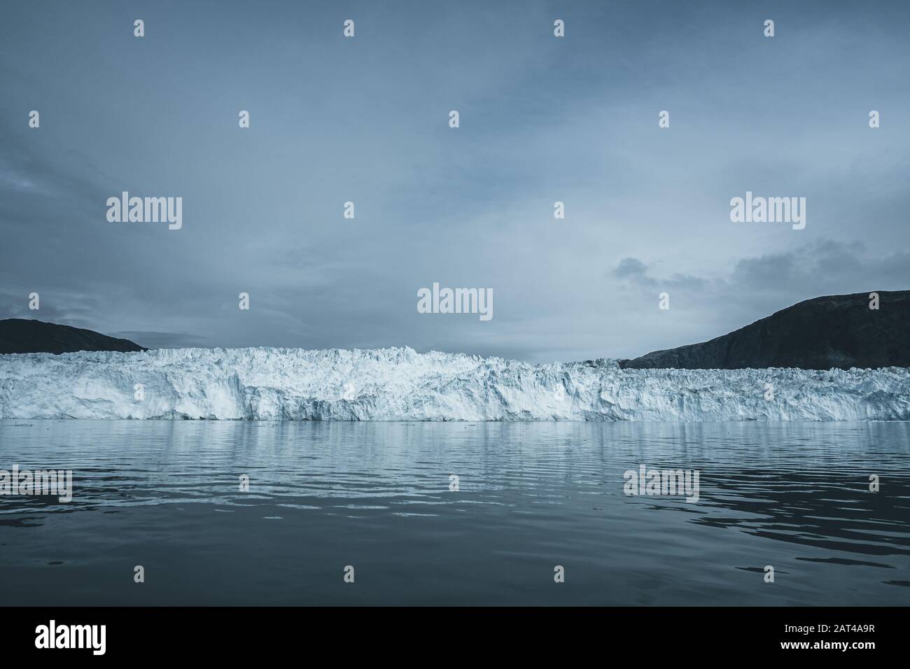 Close Up shot of huge Glacier wall. Large chunks of ice breaking off ...