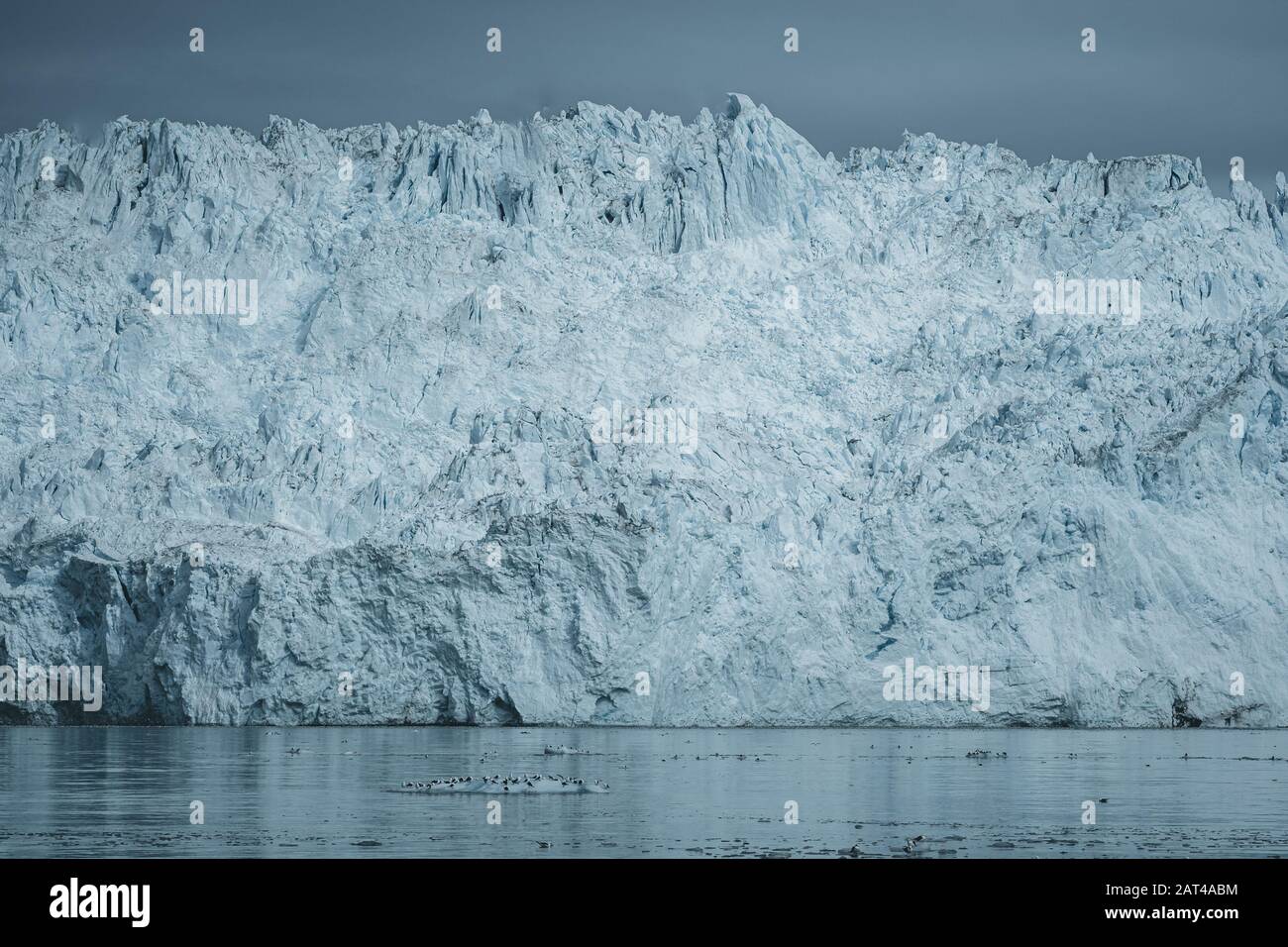 Close Up shot of huge Glacier wall. Large chunks of ice breaking off ...